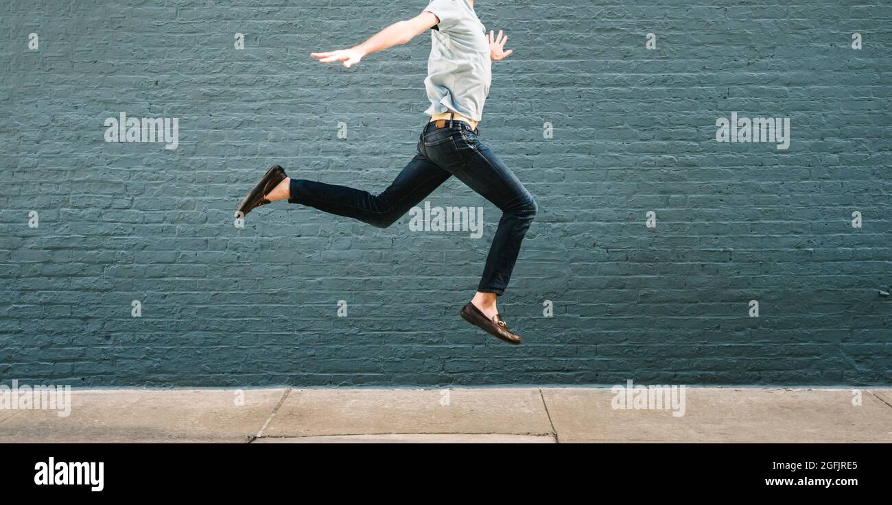 Man jumping against a wall Stock Photo - Alamy