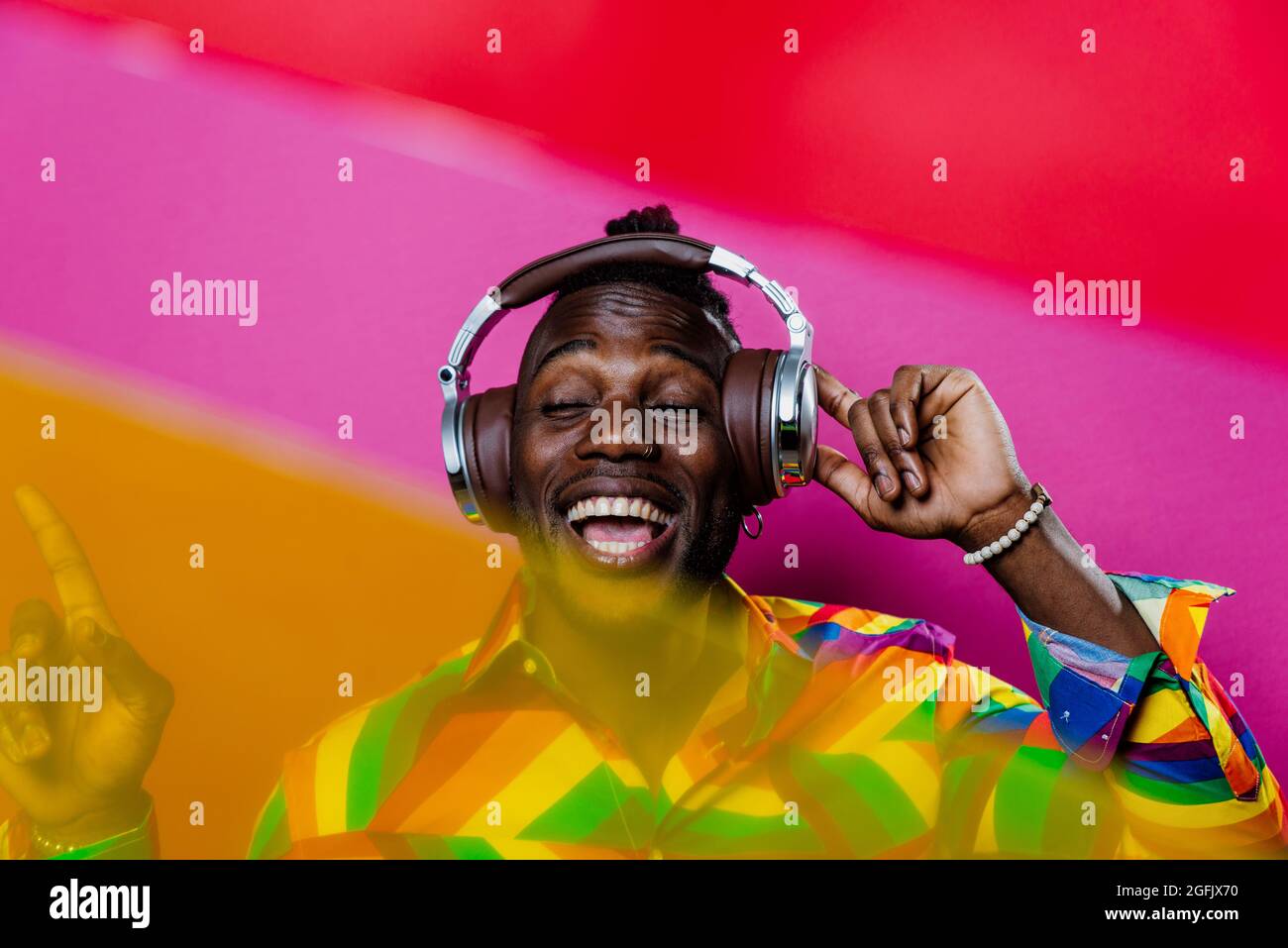 Artistic portrait with gel lights. Handsome man posing on colored ...