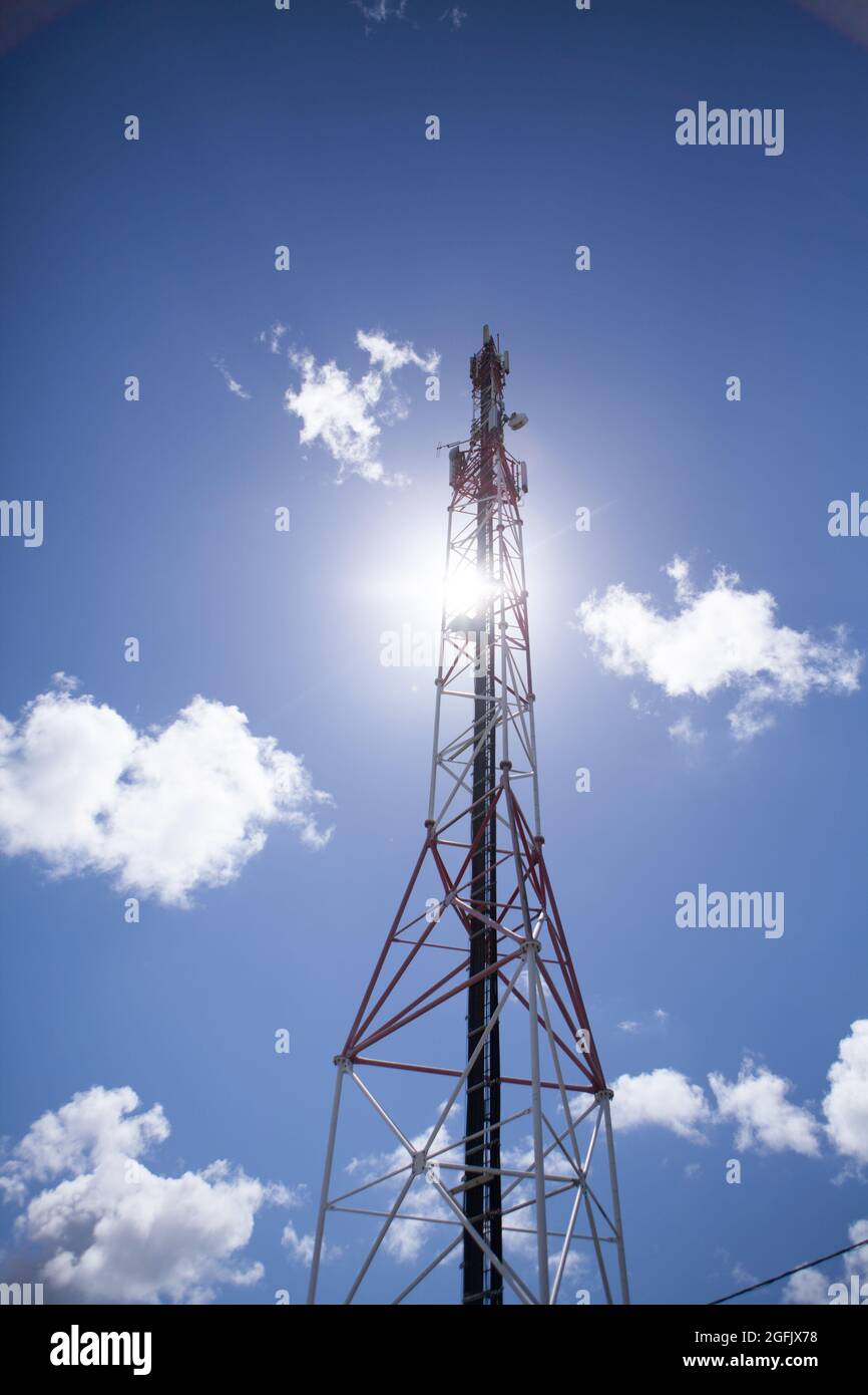 High cell phone tower relay antenna on a beautiful sunny blue sky at ...