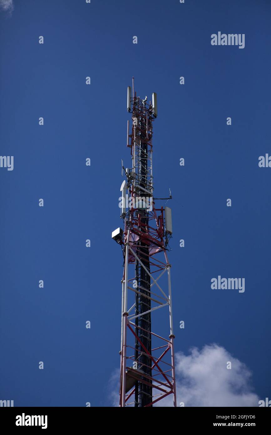 High cell phone tower relay antenna on a beautiful sunny blue sky at ...