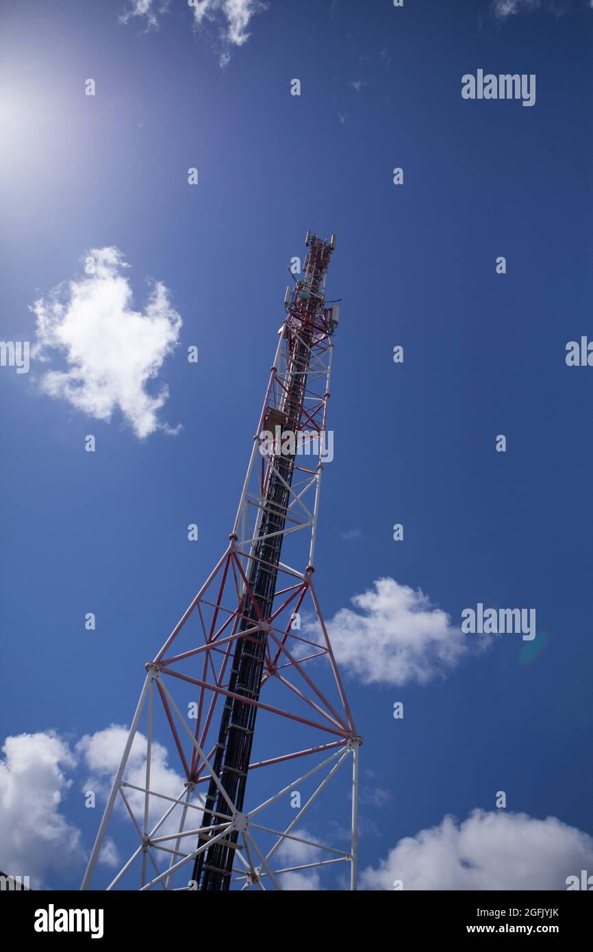 High cell phone tower relay antenna on a beautiful sunny blue sky at ...