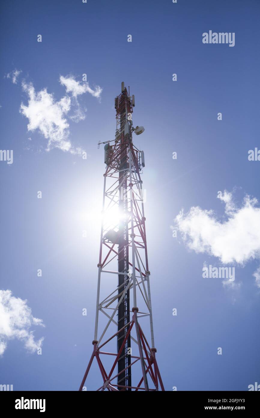 High cell phone tower relay antenna on a beautiful sunny blue sky at ...