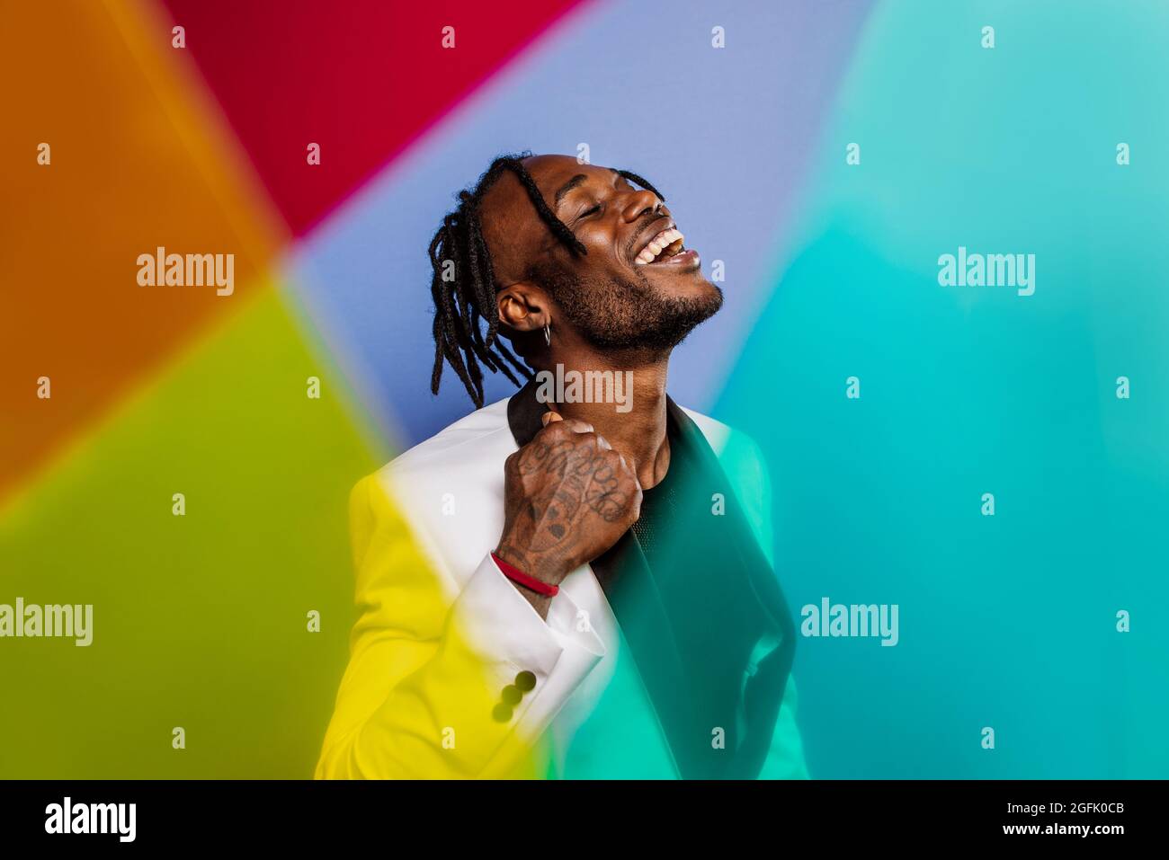 Artistic portrait with gel lights. Handsome man posing on colored ...