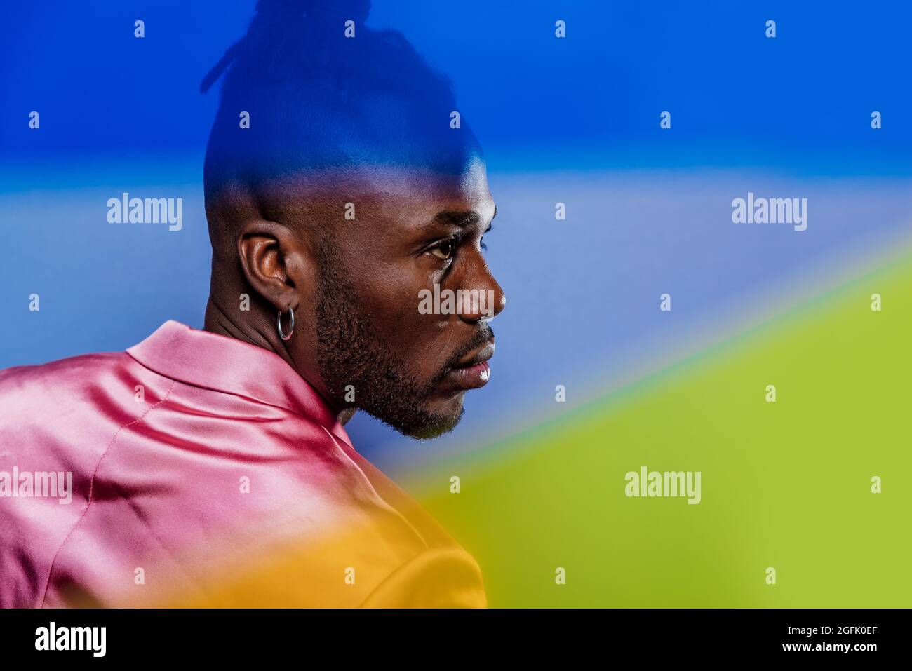 Artistic portrait with gel lights. Handsome man posing on colored ...