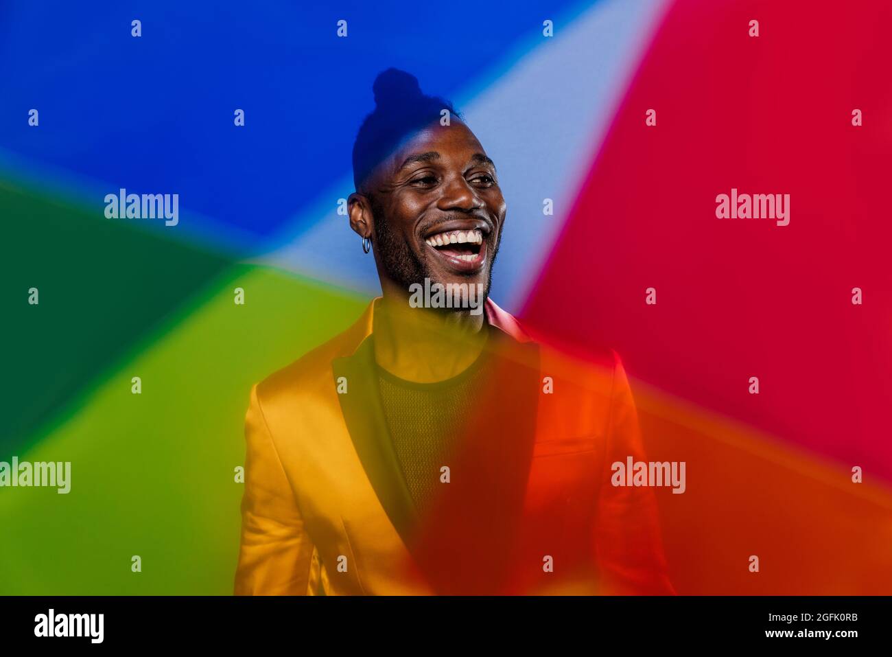 Artistic portrait with gel lights. Handsome man posing on colored ...