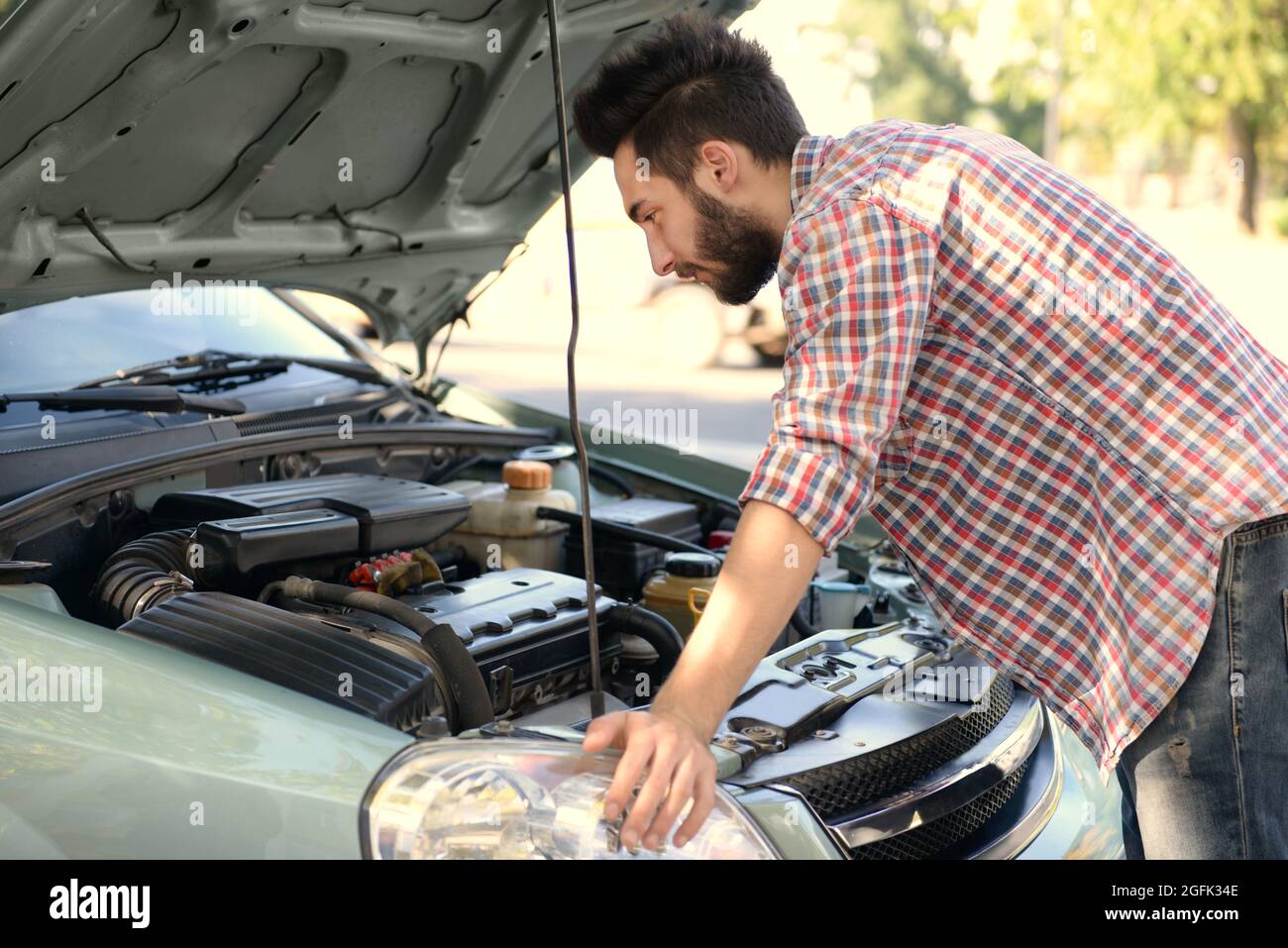 Young handsome man looking under car hood Stock Photo - Alamy