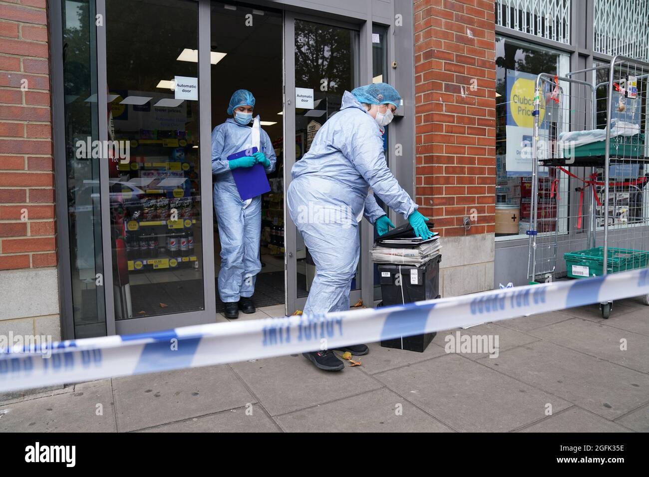 Police officers in forensic suits outside Tesco Express on Fulham ...