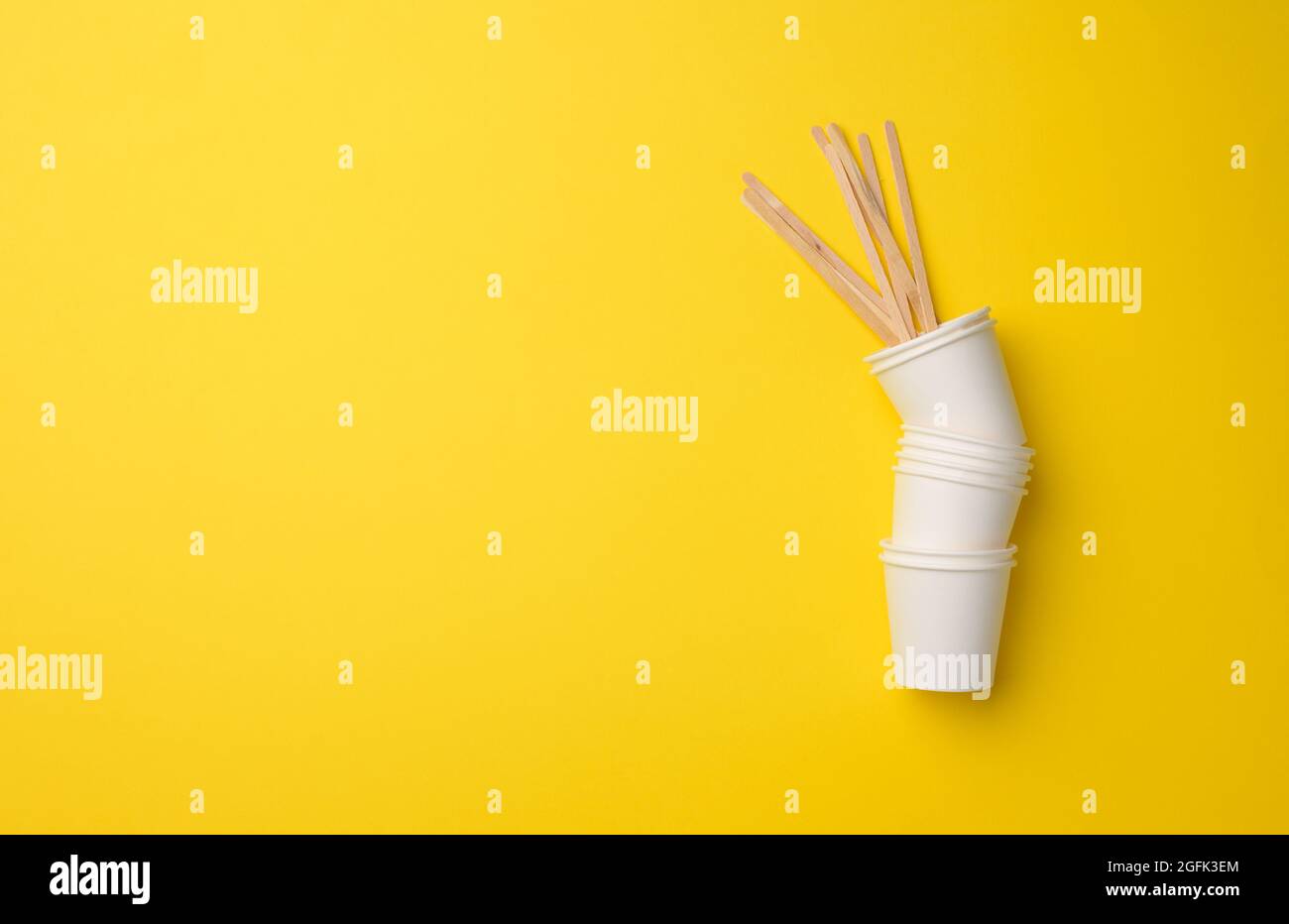 stack of white paper cups on a yellow background. Plastic rejection ...