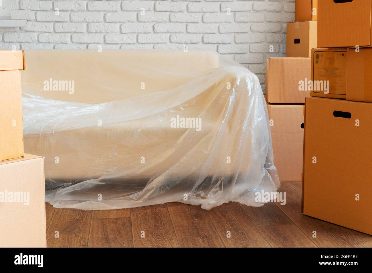 Packed sofa and stack of cardboard boxes in a room. Moving concept ...