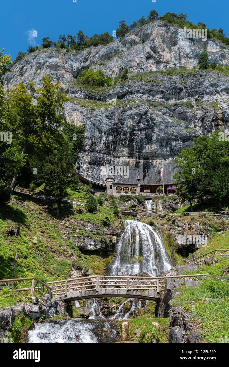 Ensemble of buildings with waterfall in front of the St. Beatus Caves ...