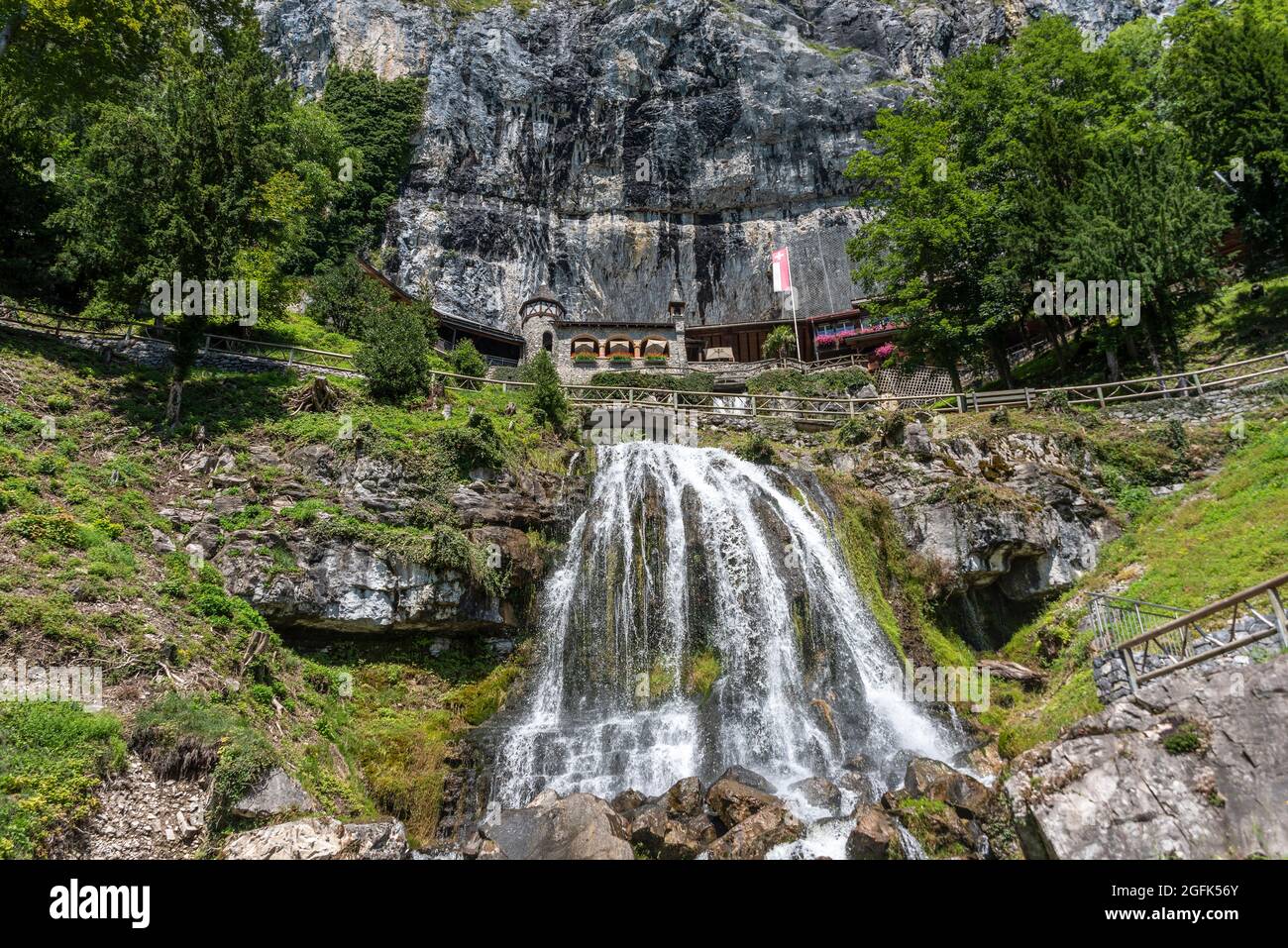 Ensemble of buildings with waterfall in front of the St. Beatus Caves ...