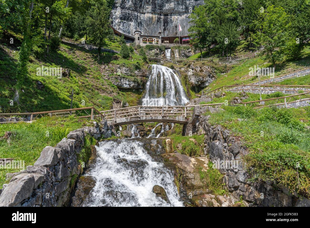 Ensemble of buildings with waterfall in front of the St. Beatus Caves ...