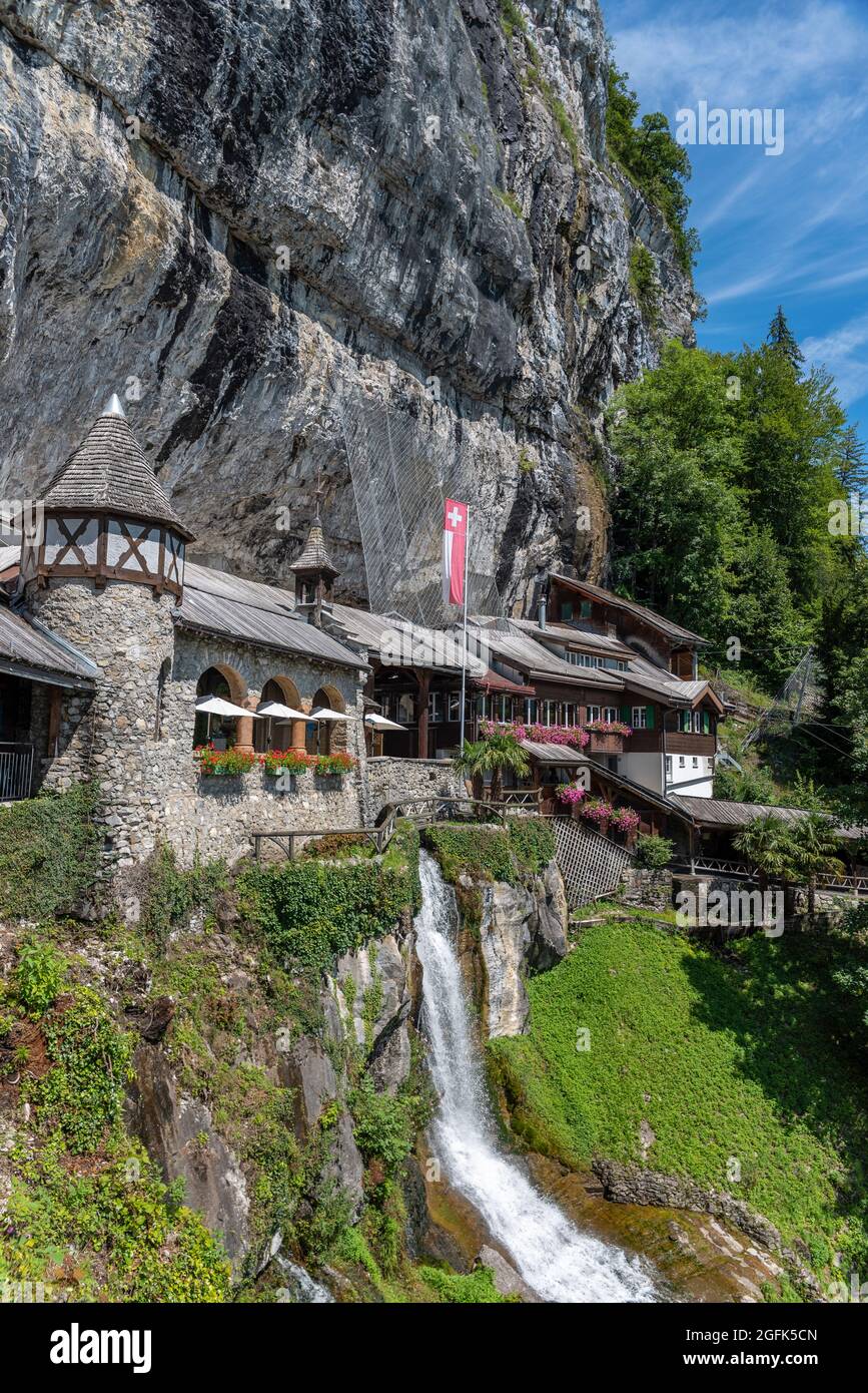 Ensemble of buildings with waterfall in front of the St. Beatus Caves ...