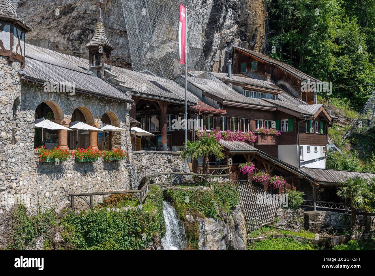 Ensemble of buildings with waterfall in front of the St. Beatus Caves ...