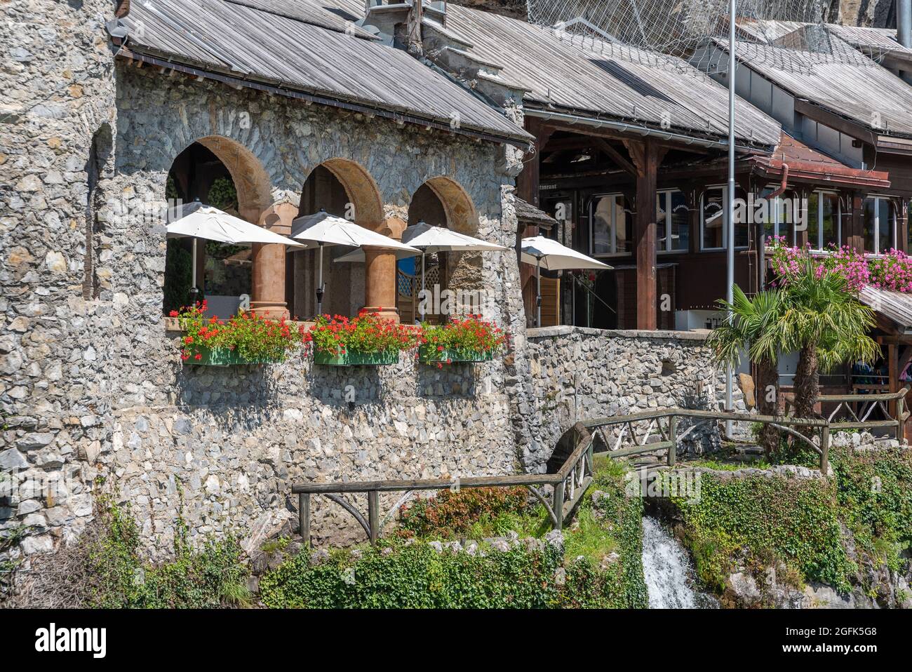 Ensemble of buildings with waterfall in front of the St. Beatus Caves ...