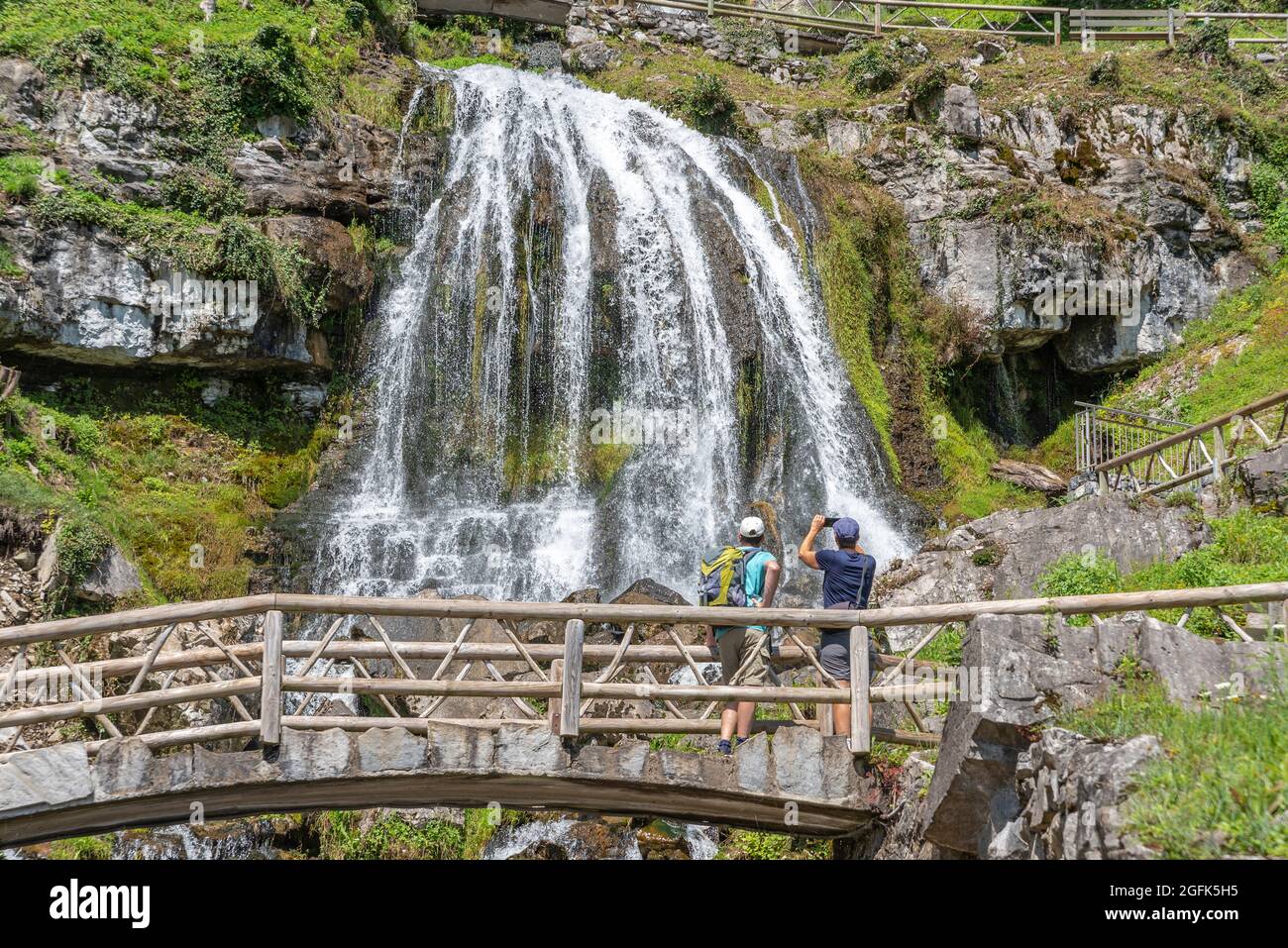 Hikers at the waterfall in front of the St. Beatus Caves, Beatenberg ...