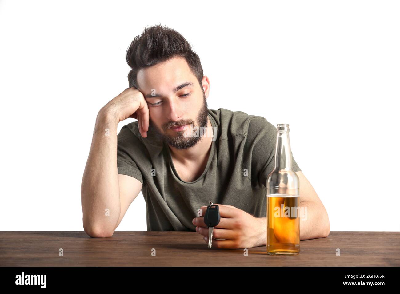 Young drunk man with car key and bottle of beer on grey background ...
