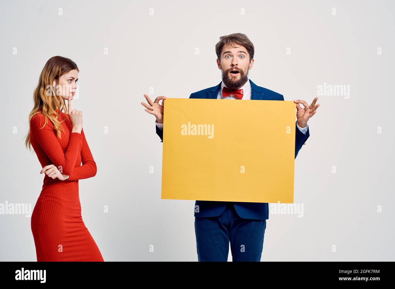 man and woman standing next to advertising posing discount Stock Photo ...