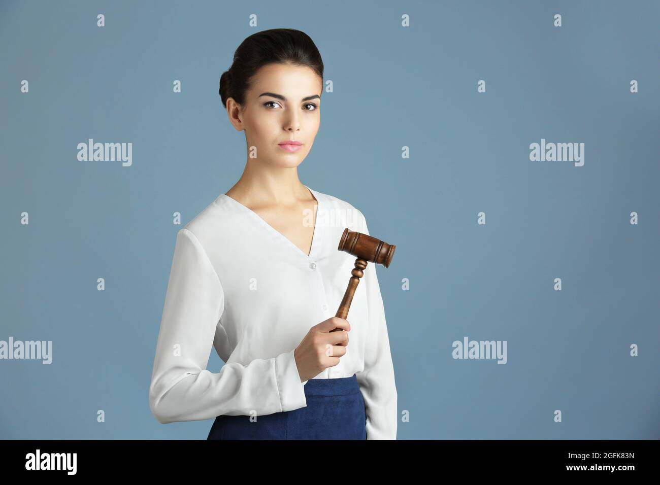 Woman with judge gavel on gray background Stock Photo - Alamy