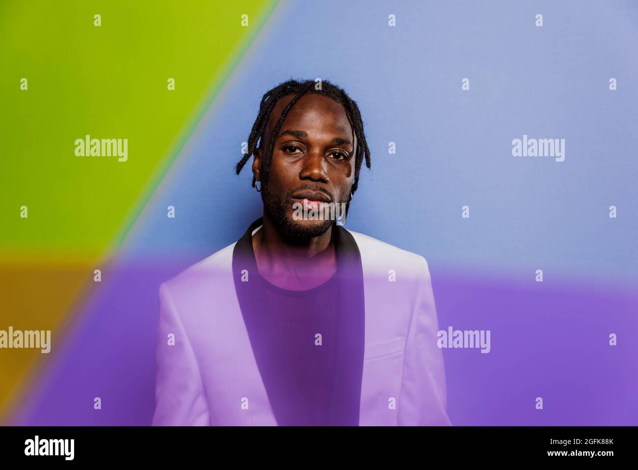 Artistic portrait with gel lights. Handsome man posing on colored ...