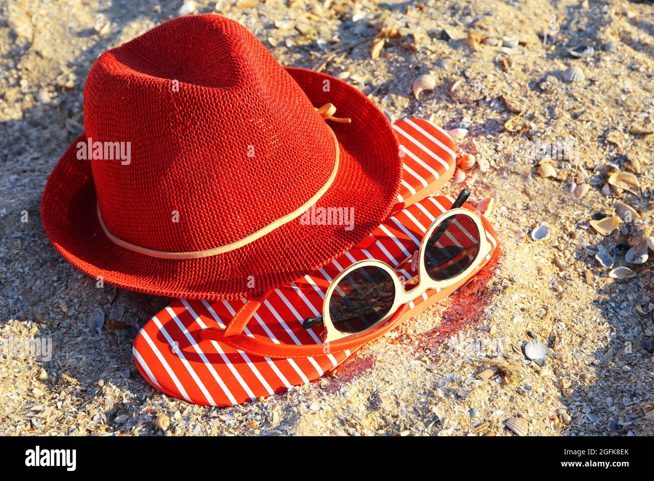 Red hat, sandals and sunglasses on sand Stock Photo - Alamy