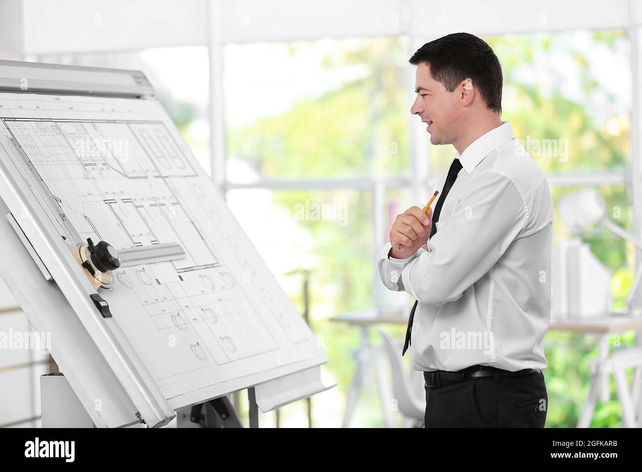 Young creative male engineer making project on drawing board Stock ...