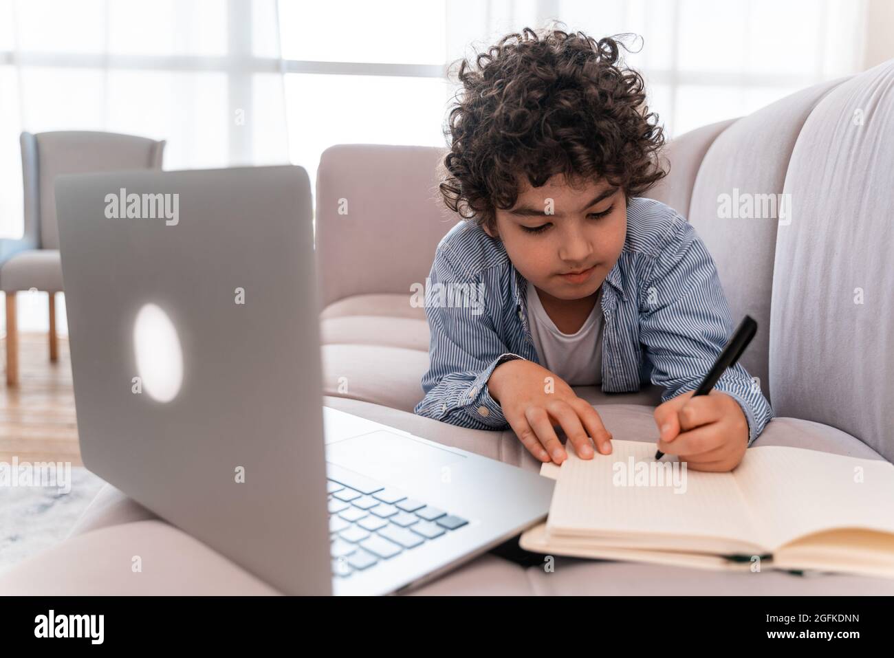 little kid studying on his laptop. Concept about childhood and ...