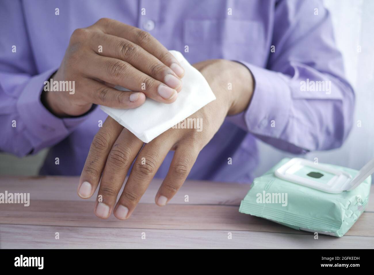 man disinfecting his hands with a wet wipe Stock Photo - Alamy