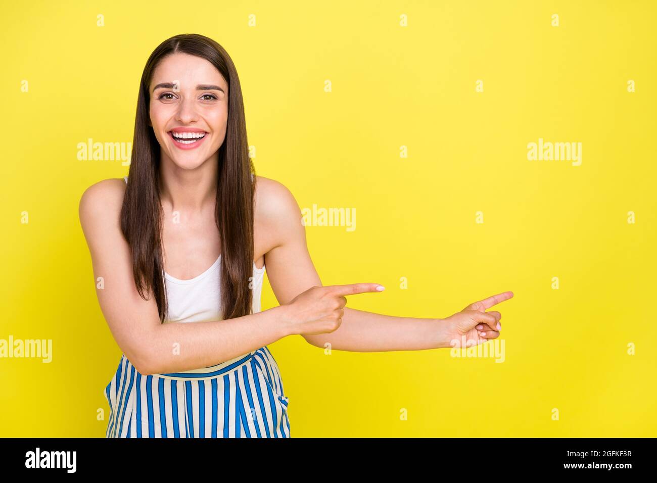 Portrait of attractive cheerful girl demonstrating copy space ad advert ...