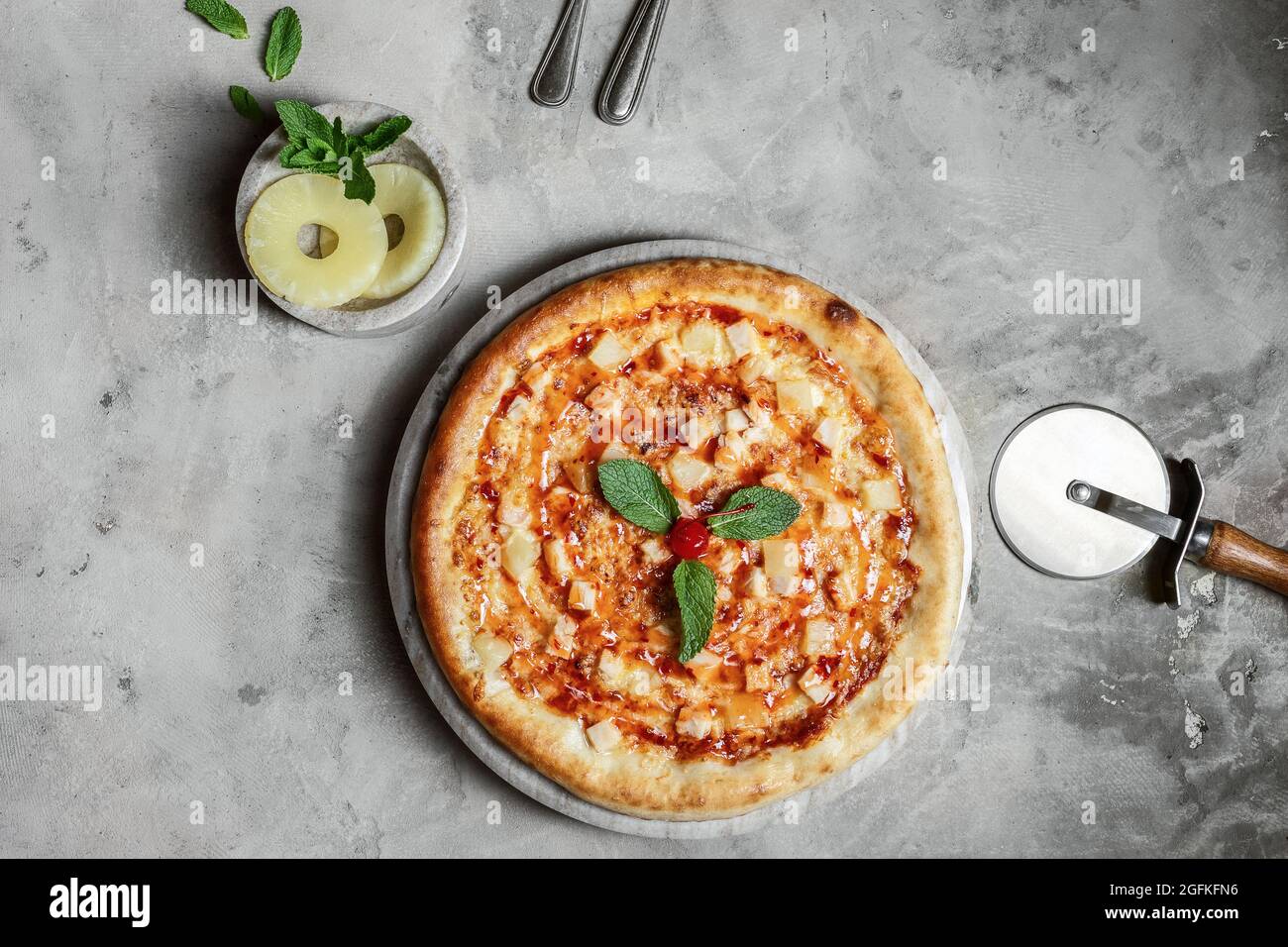 Tasty pizza with chicken, mozzarella, pineapple on marble round tray ...
