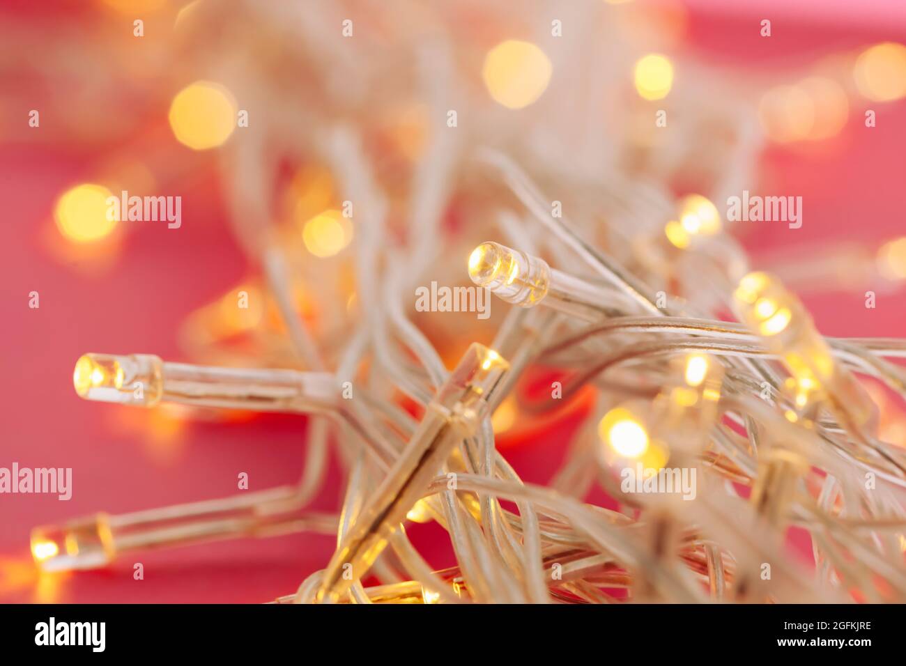 Illuminated garland lights on bright pink background Stock Photo - Alamy