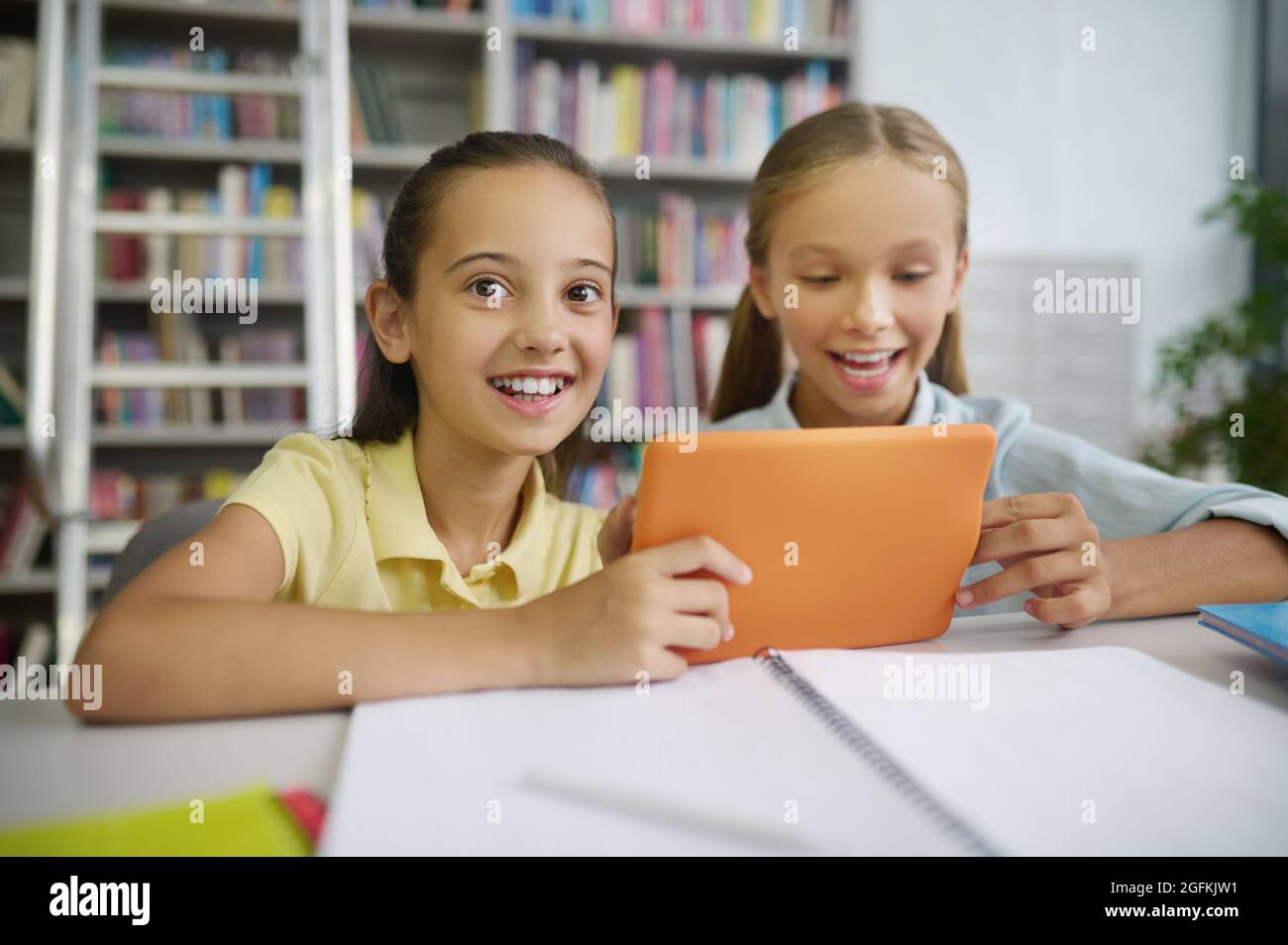 Cheerful friends with a tablet computer sitting at the desk Stock Photo ...