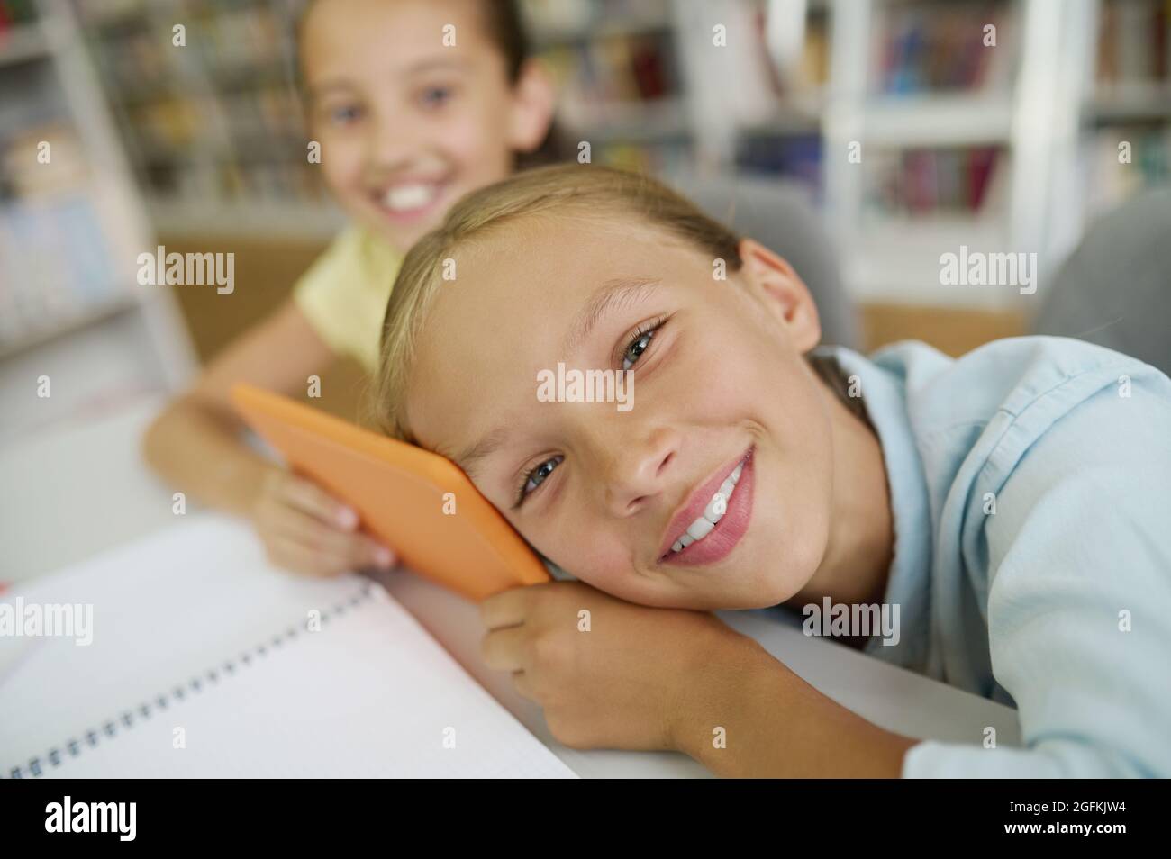 Two joyful classmates at a public library Stock Photo - Alamy