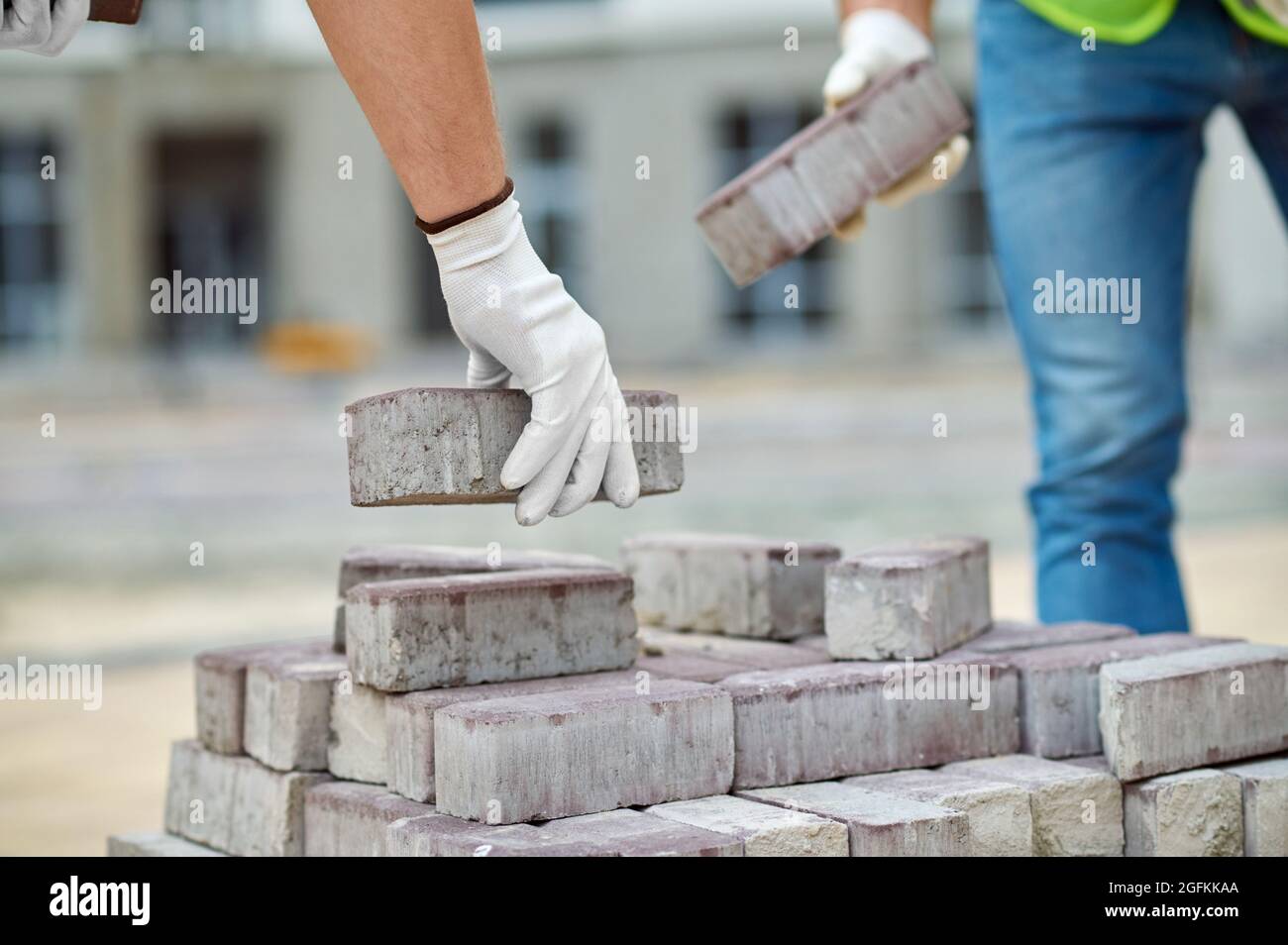 Caucasian male workers holding building materials with gloved hands ...
