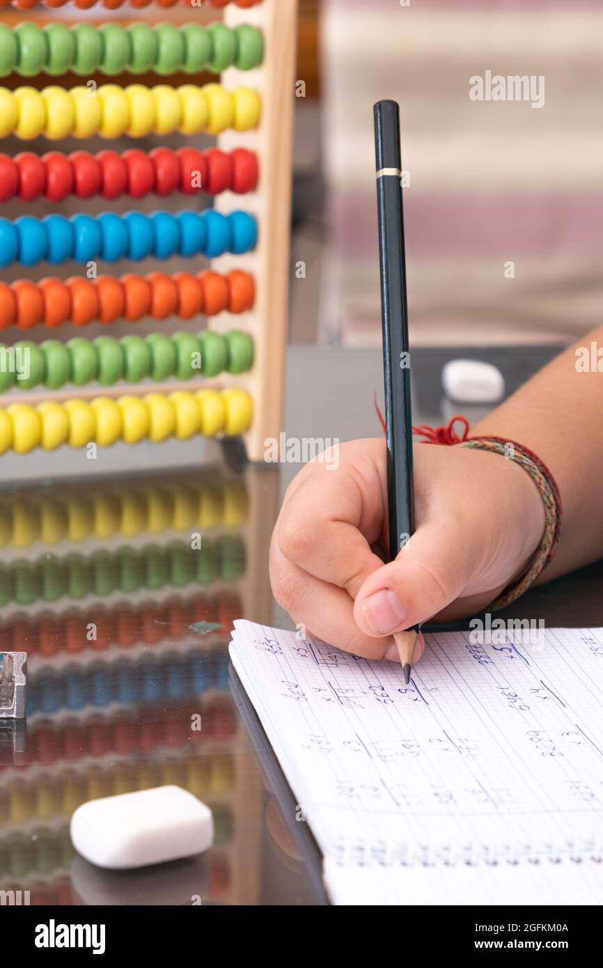Little girl doing math homework with an abacus. Back to school concept ...
