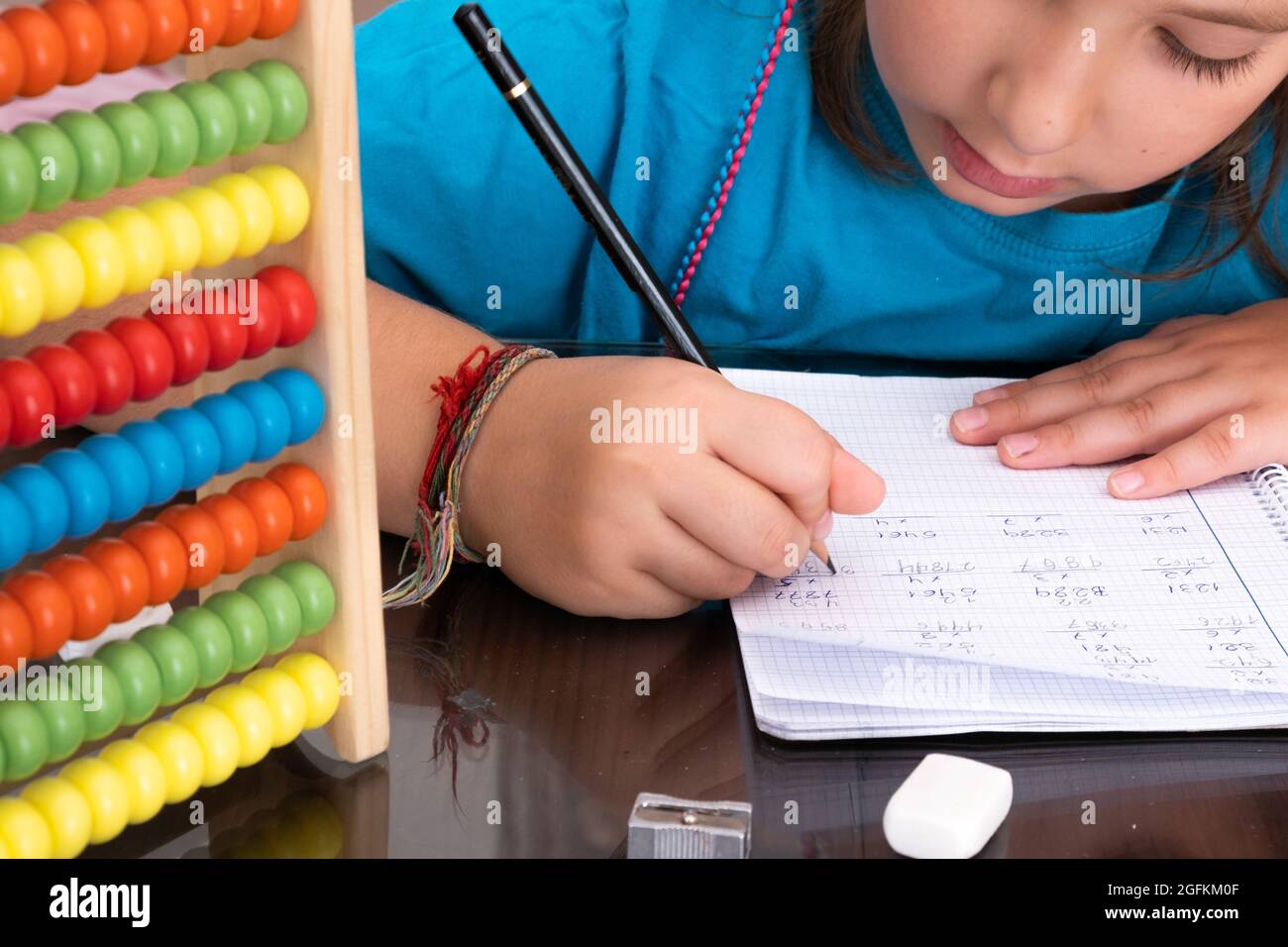 Little girl doing math homework with an abacus. Back to school concept ...