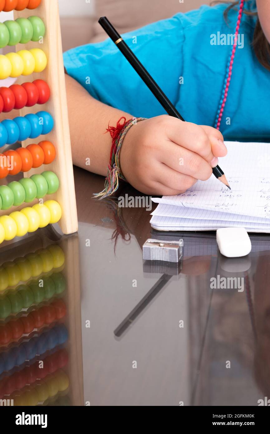 Little girl doing math homework with an abacus. Back to school concept ...