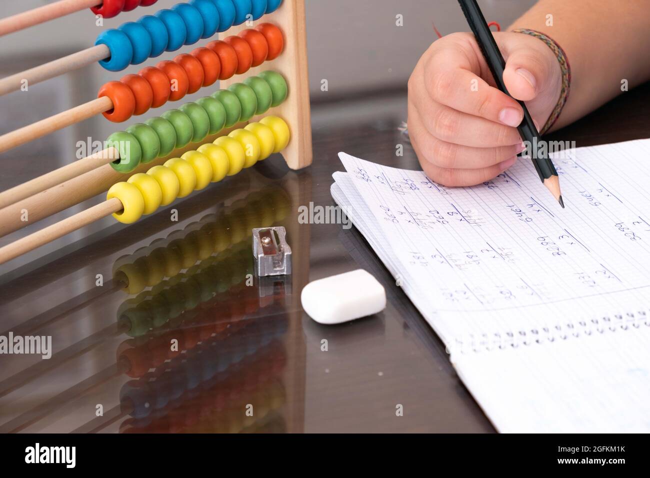 Little girl doing math homework with an abacus. Back to school concept ...