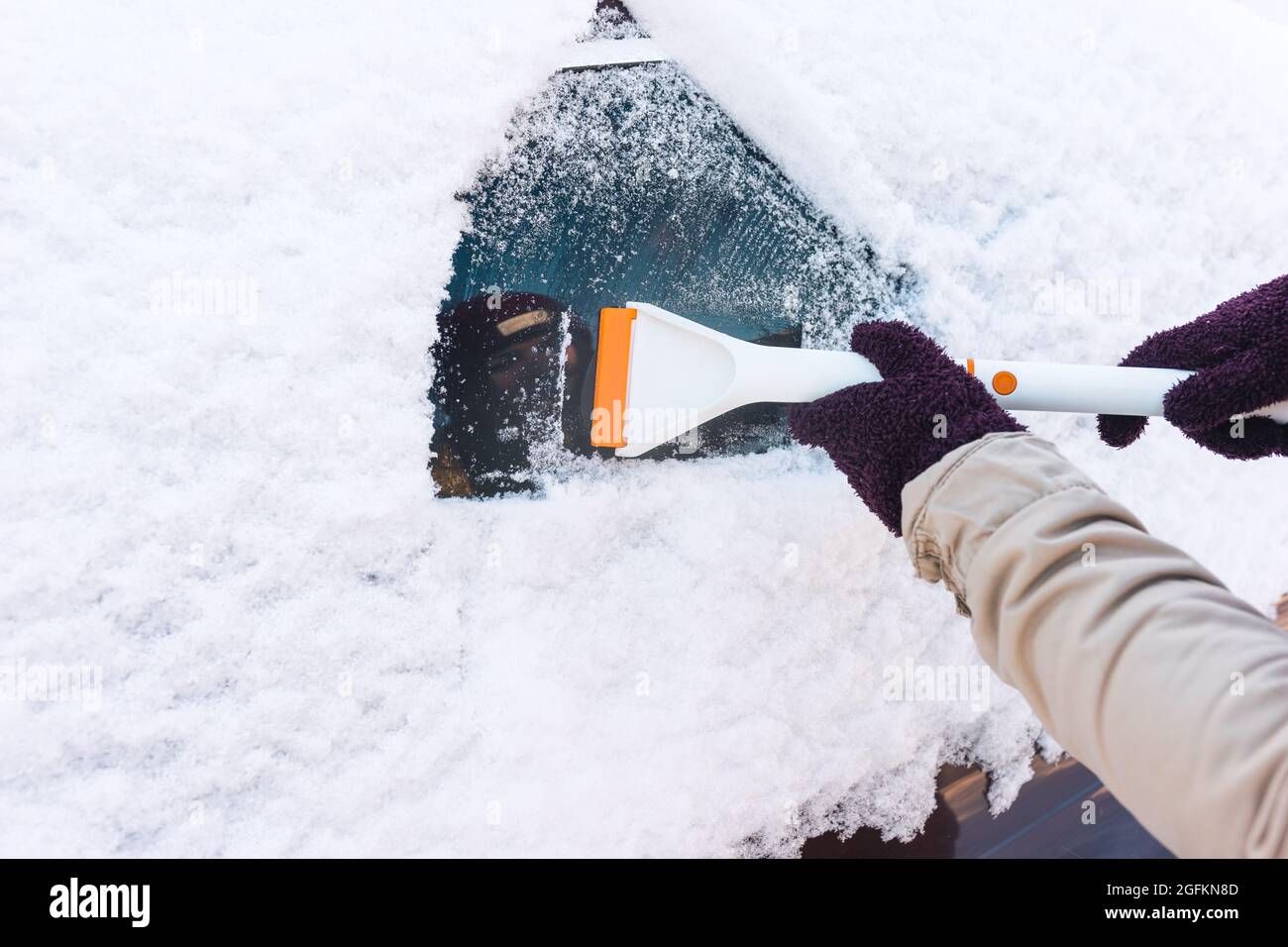 Person cleans snow from car windows with a scraper Stock Photo - Alamy