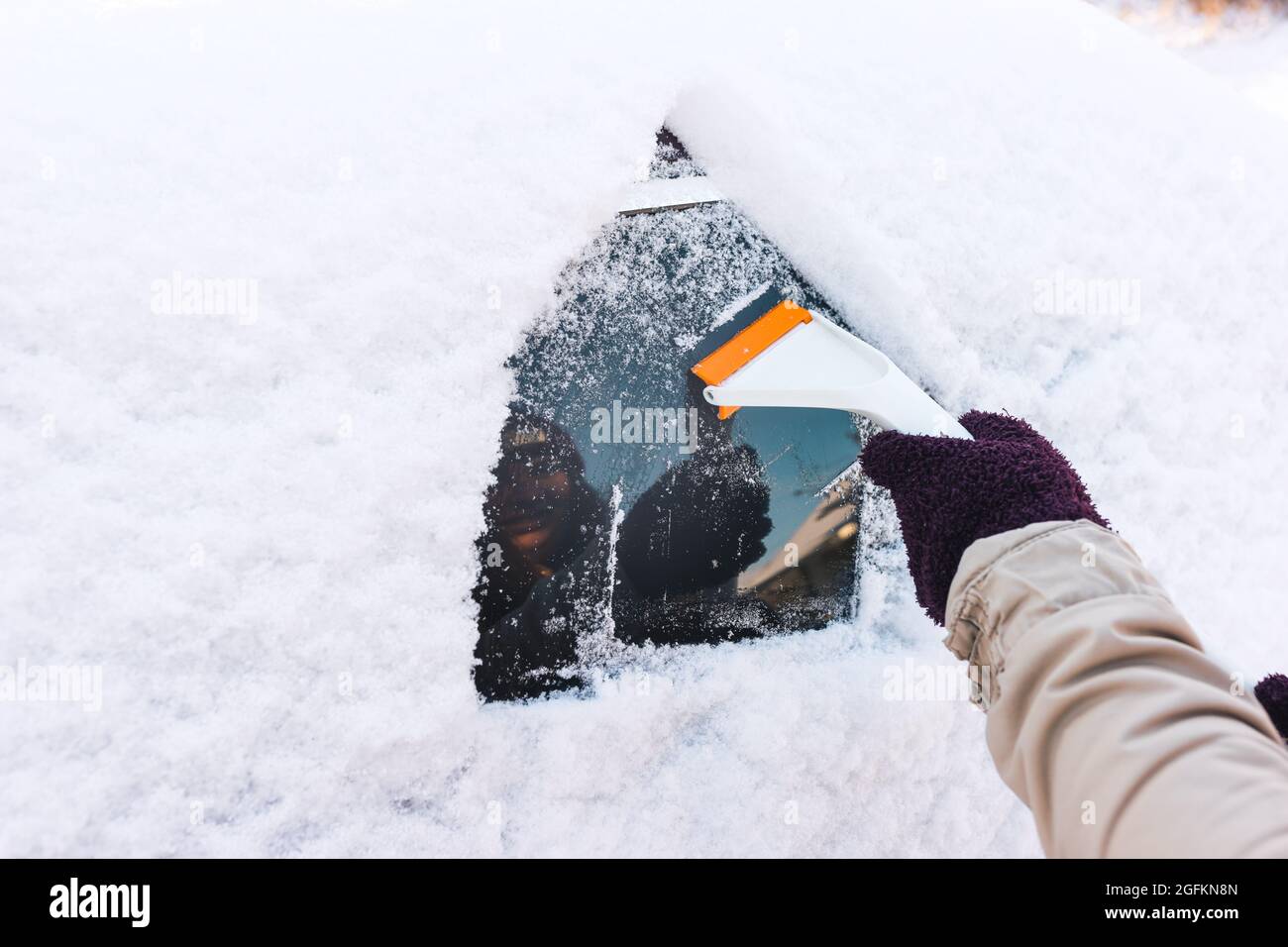 Person cleans snow from car windows with a scraper Stock Photo - Alamy