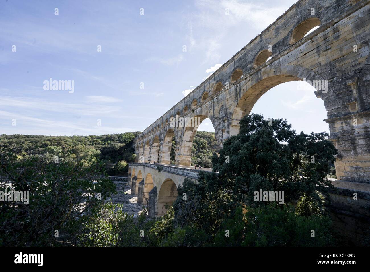 Pond du Gard roman aqueduct, with sunlight and blue sky, close view ...