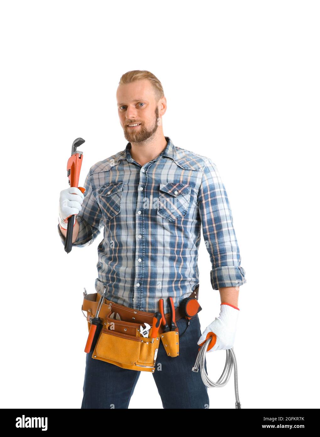 Handsome plumber with pipe wrench and flexible hose isolated on white ...
