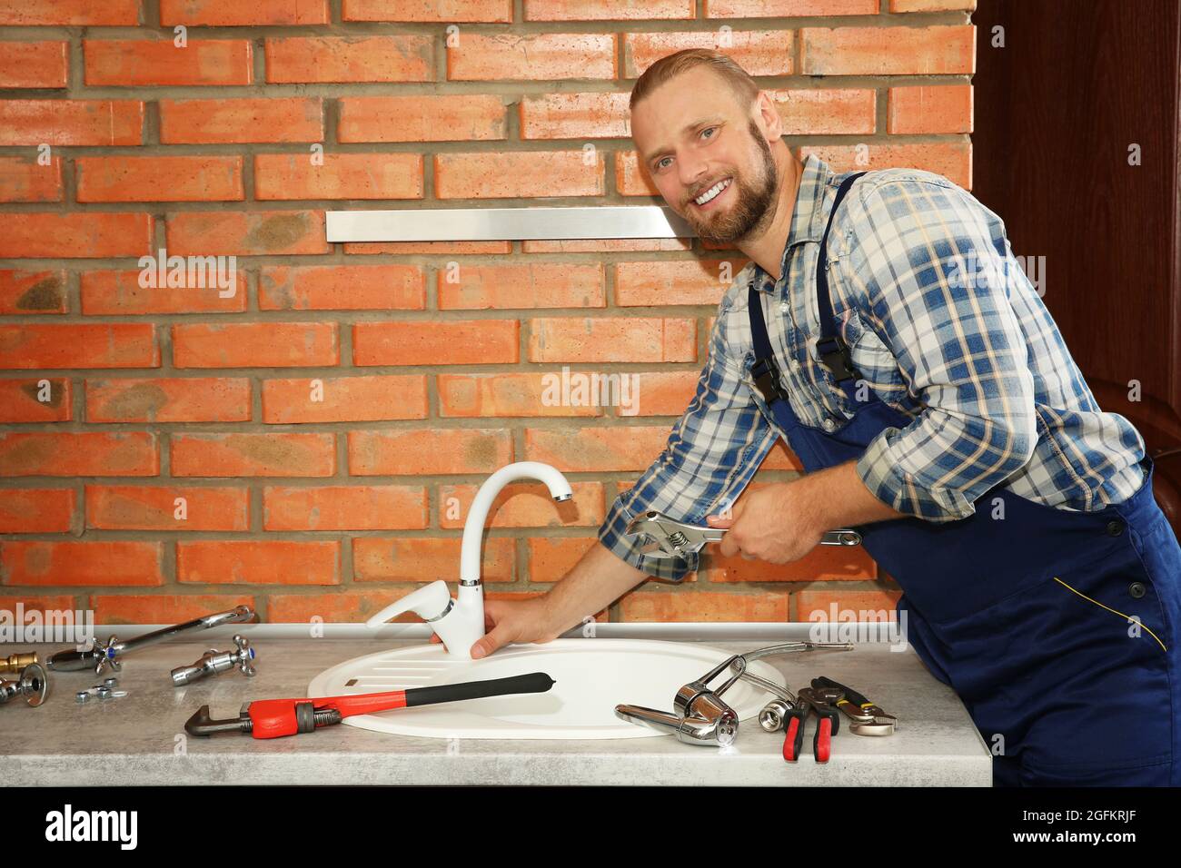 Handsome smiling plumber at the kitchen hi-res stock photography and ...