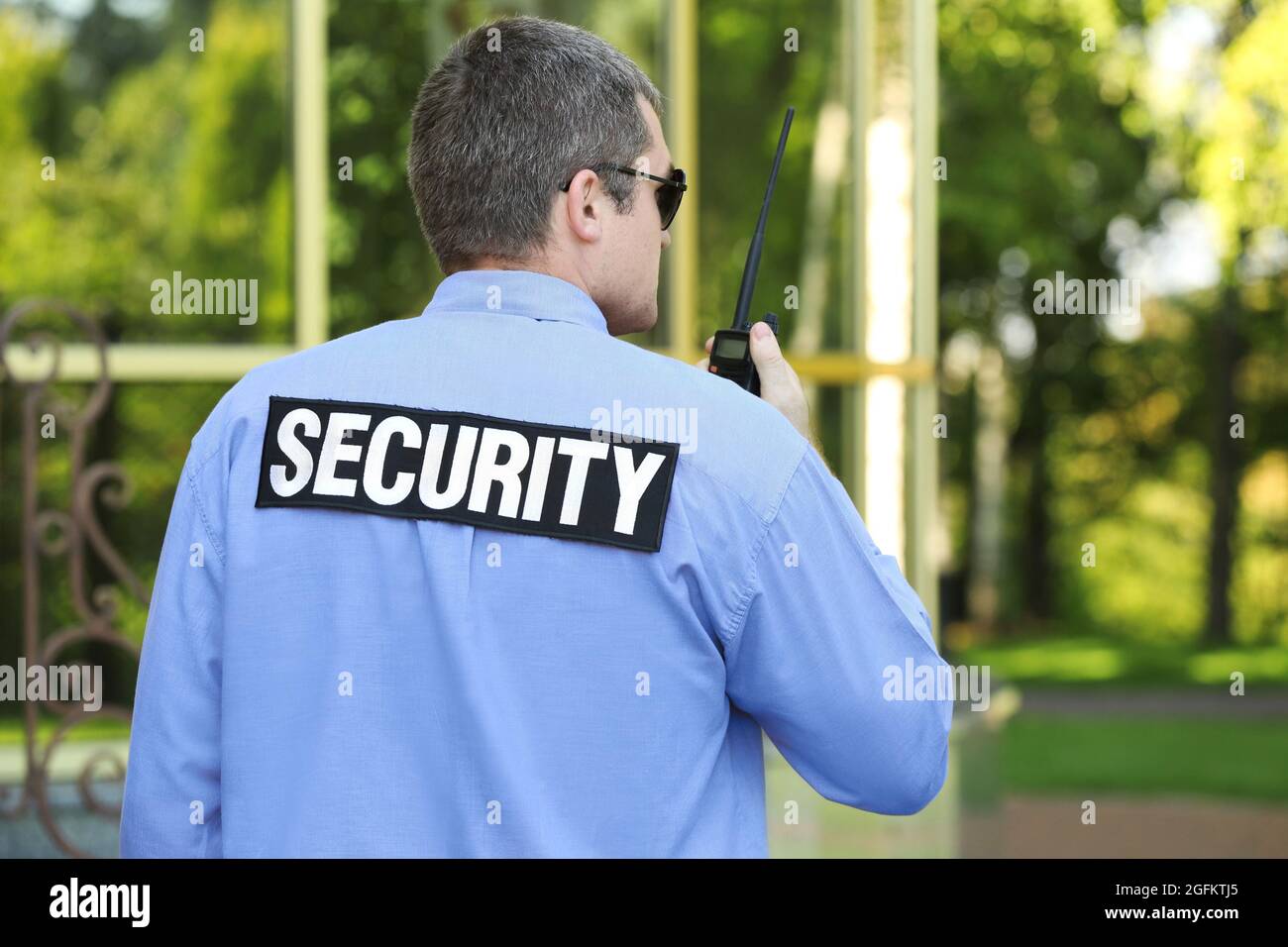 Male security guard near glass building facade Stock Photo - Alamy