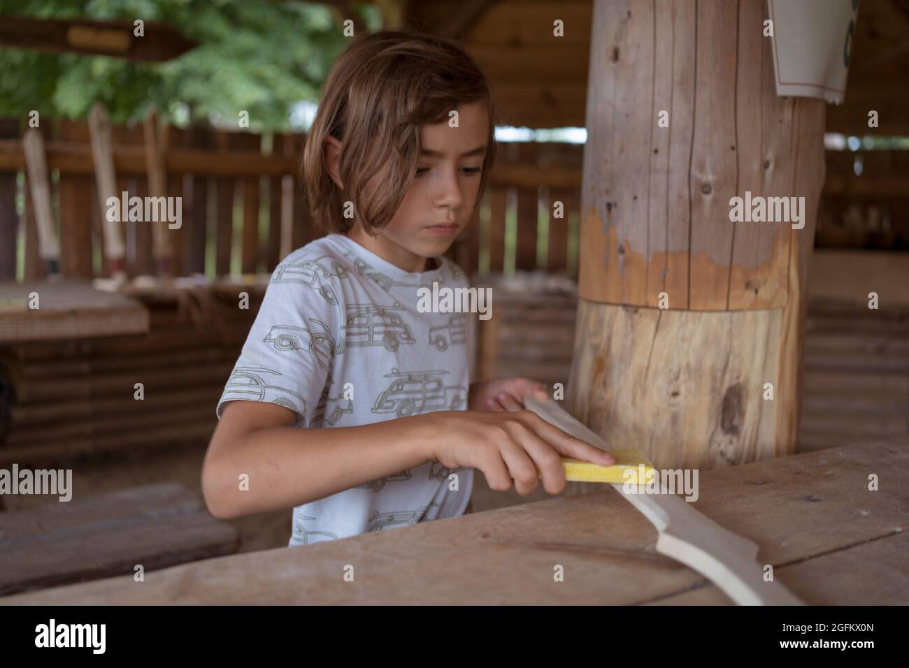 Boy making wooden detail in carpentry workshop Stock Photo - Alamy