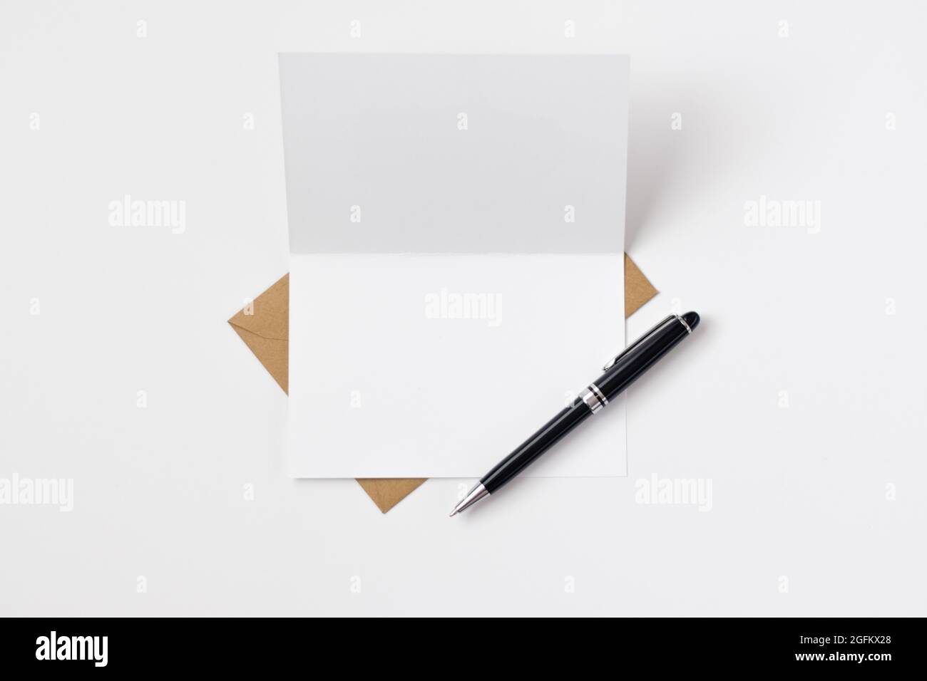 Open blank card with brown envelope and black and silver pen Stock ...