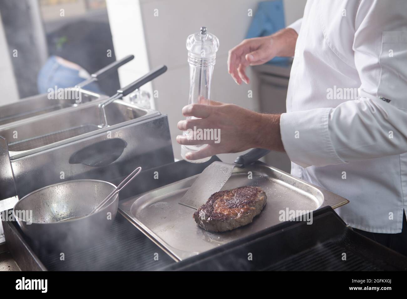 Unrecognizable chef salting rib eye grilled steak Stock Photo - Alamy