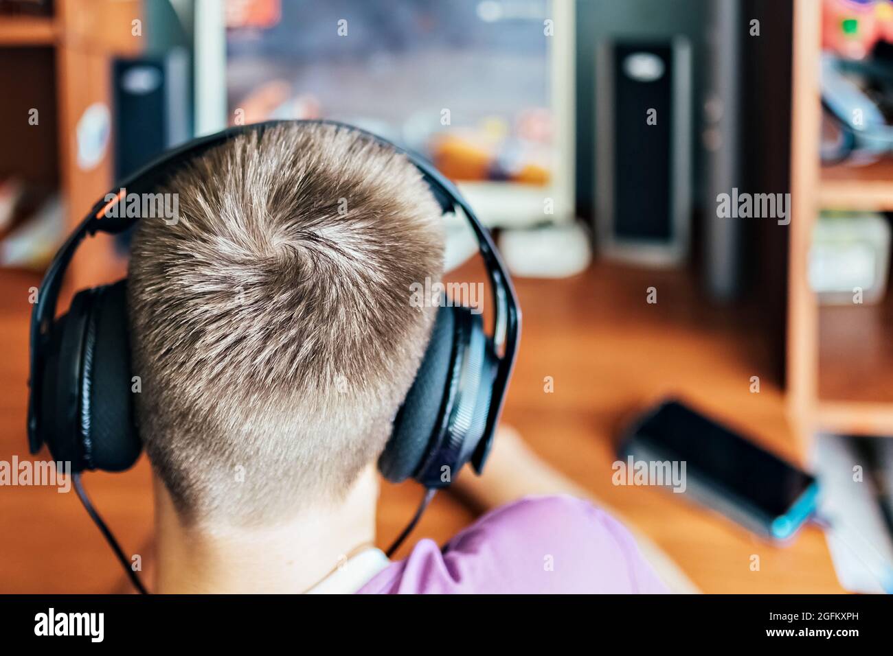 A teenage boy, a young man playing video games on a computer, using ...
