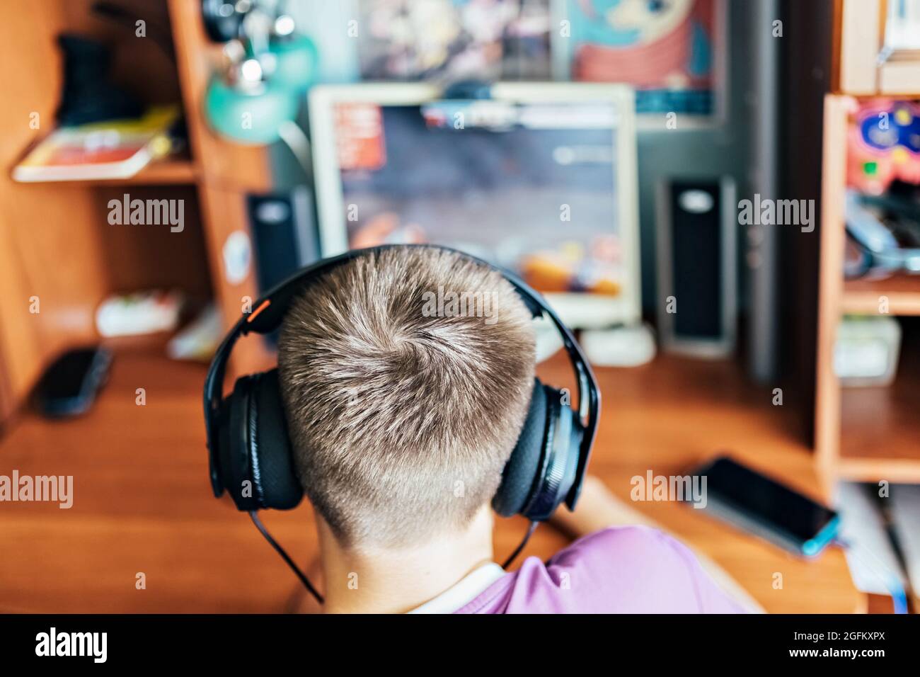 A teenage boy, a young man playing video games on a computer, using ...