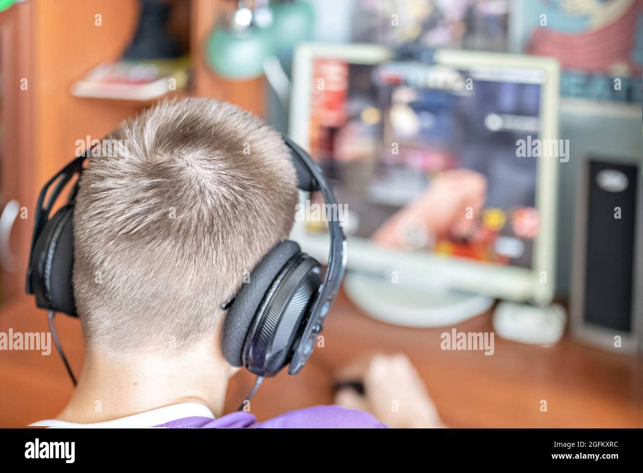 A teenage boy, a young man playing video games on a computer, using ...